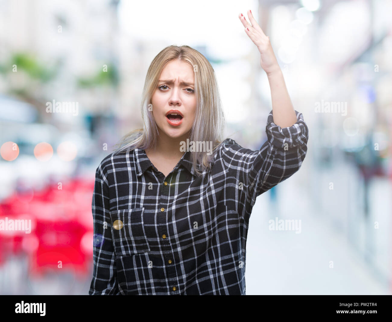 Young blonde woman over isolated background angry and mad raising fist ...