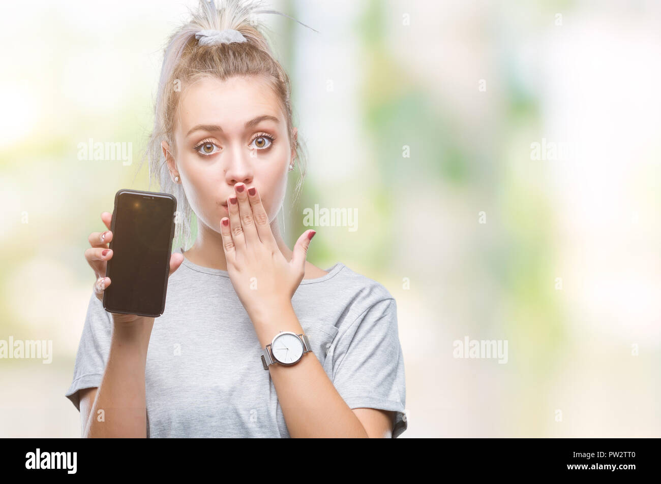 Young blonde woman showing screen of smartphone over isolated ...