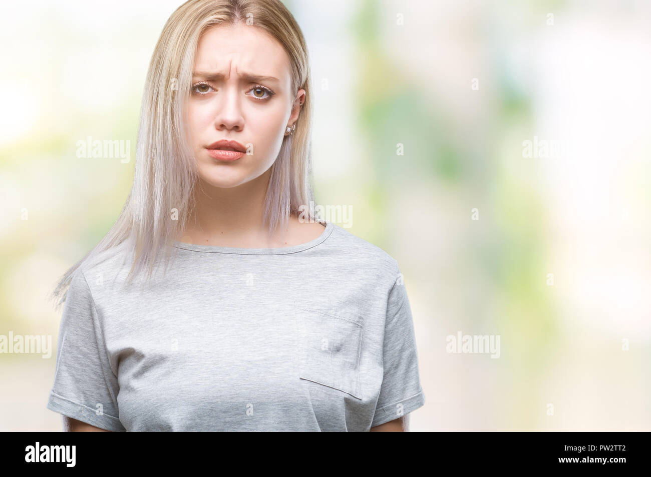 Young blonde woman over isolated background skeptic and nervous ...