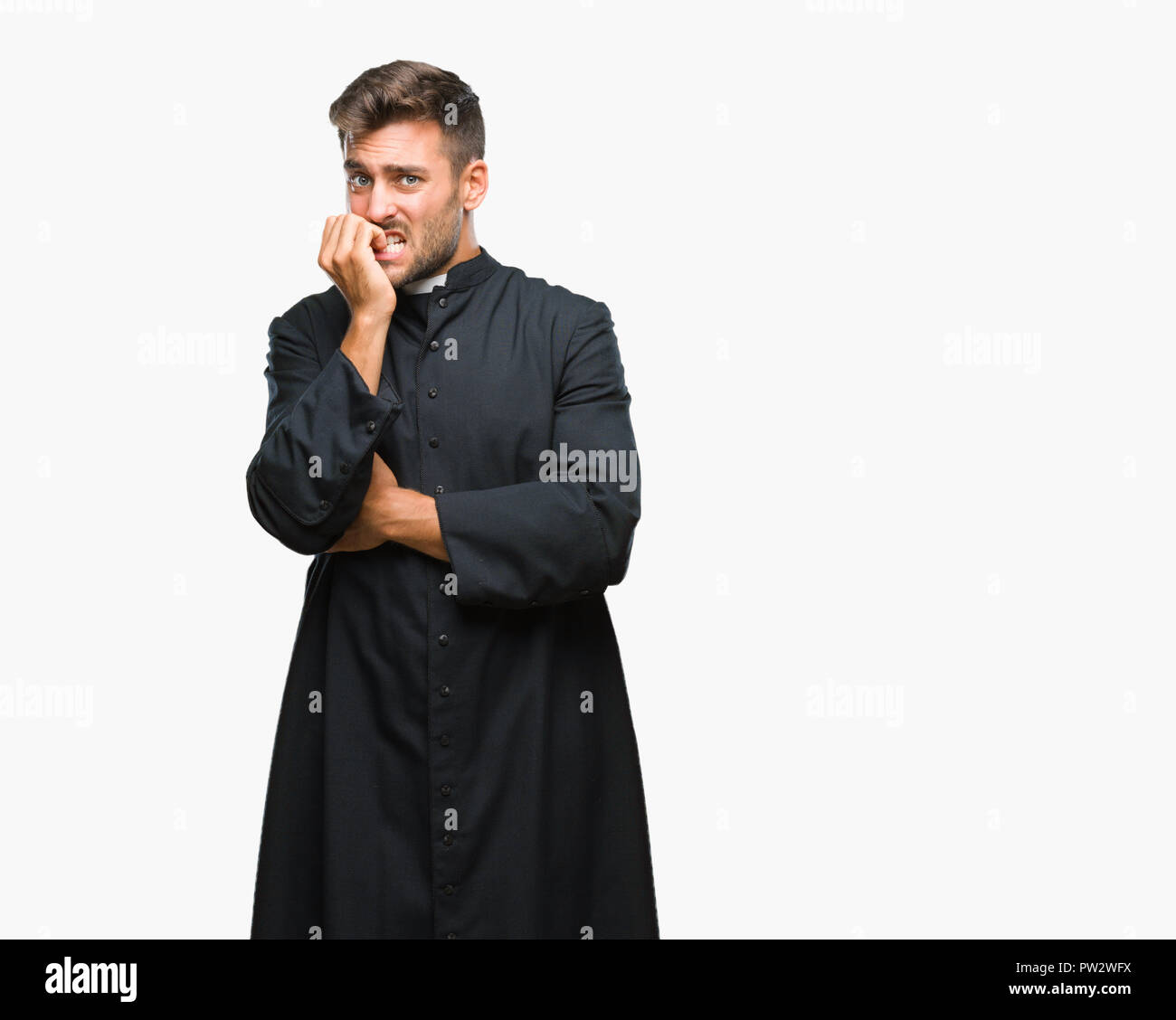 Young catholic christian priest man over isolated background looking ...