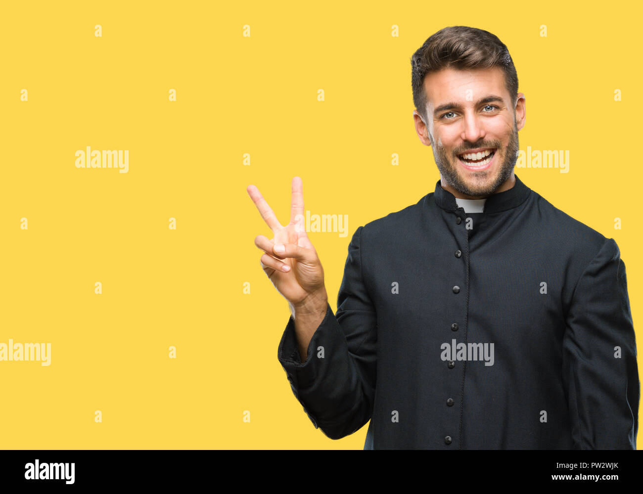 Young catholic christian priest man over isolated background smiling ...