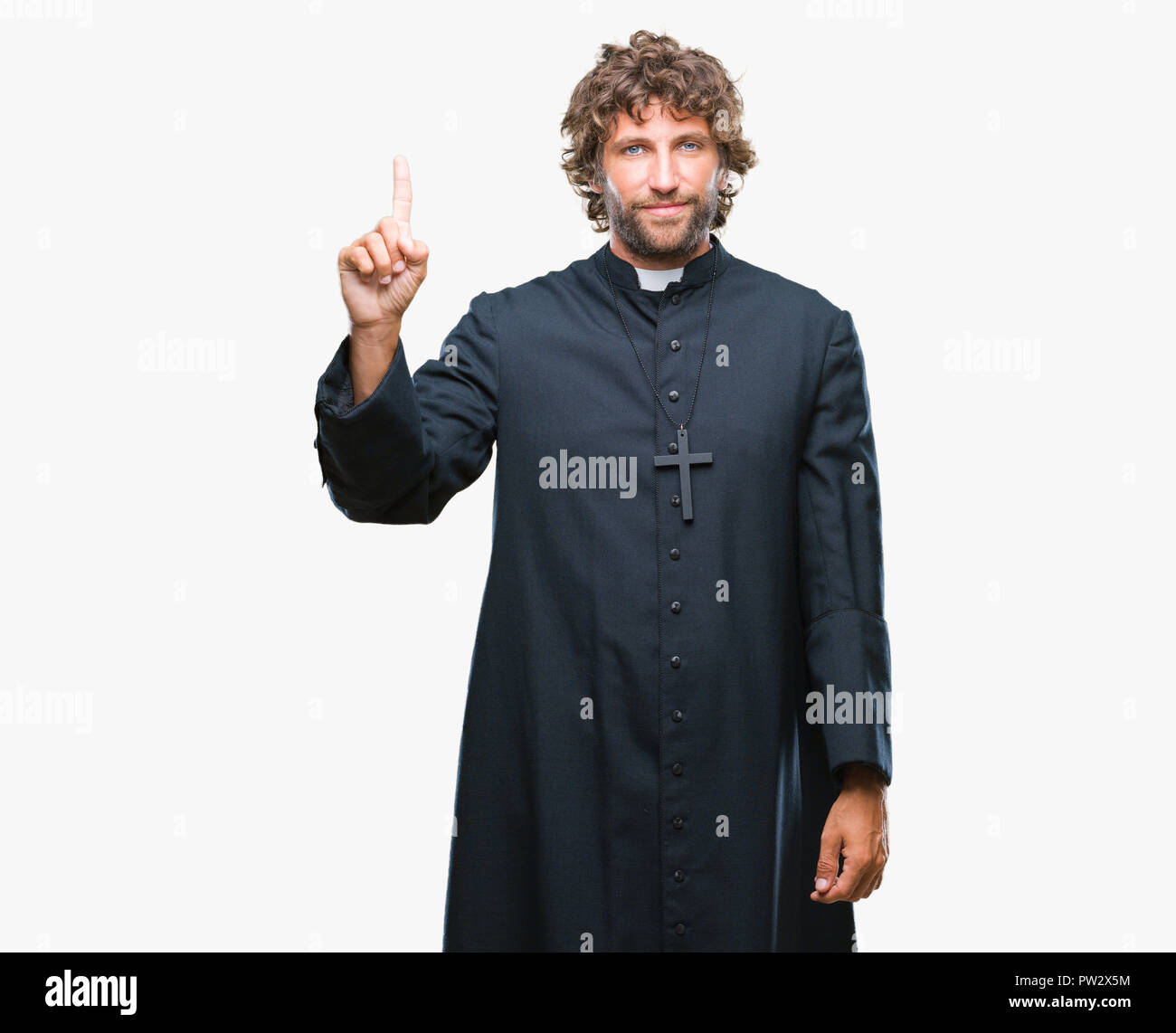 Handsome hispanic catholic priest man over isolated background showing ...