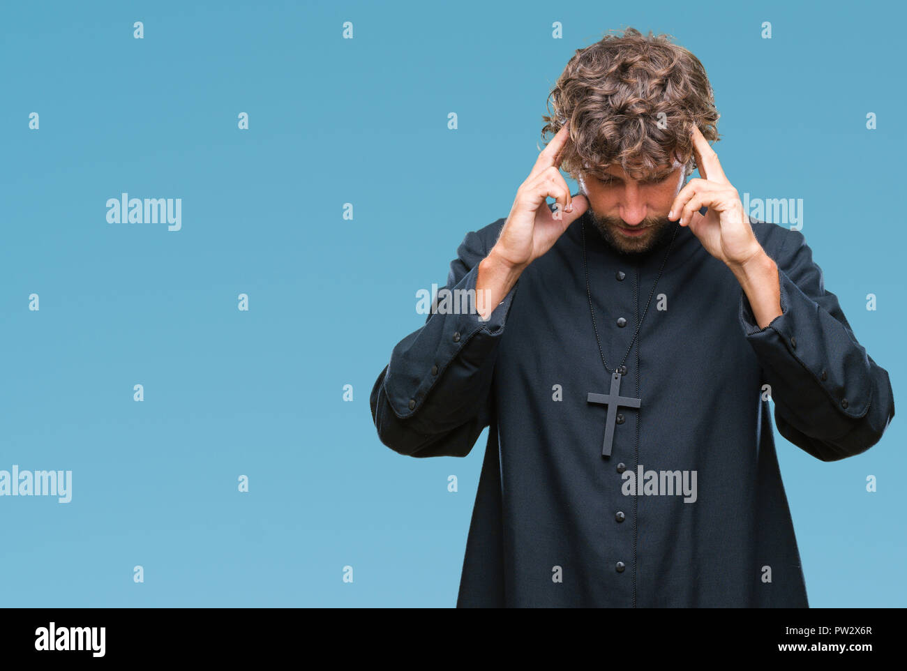 Handsome hispanic catholic priest man over isolated background with ...