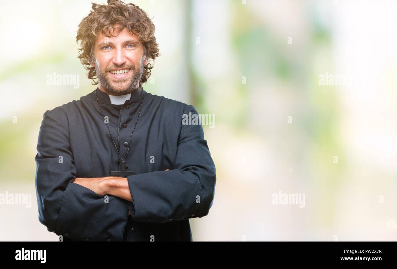 Handsome hispanic catholic priest man over isolated background happy ...