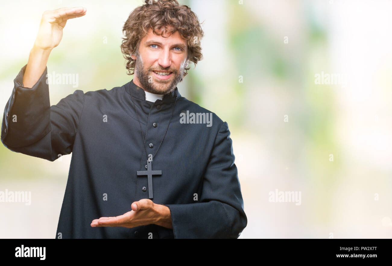 Handsome hispanic catholic priest man over isolated background ...