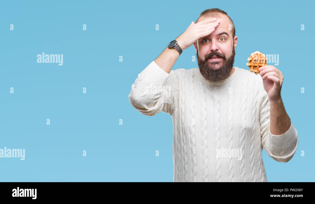 Young caucasian hipster man eating sweet waffle over isolated ...