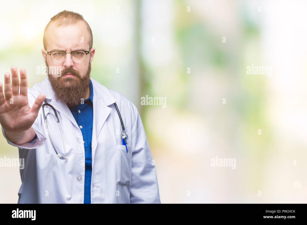 Young caucasian doctor man wearing medical white coat over isolated ...