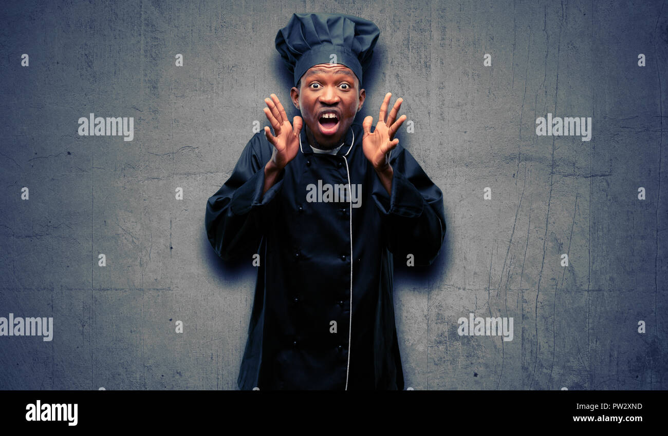 Young black cook wearing chef hat stressful keeping hands on head ...