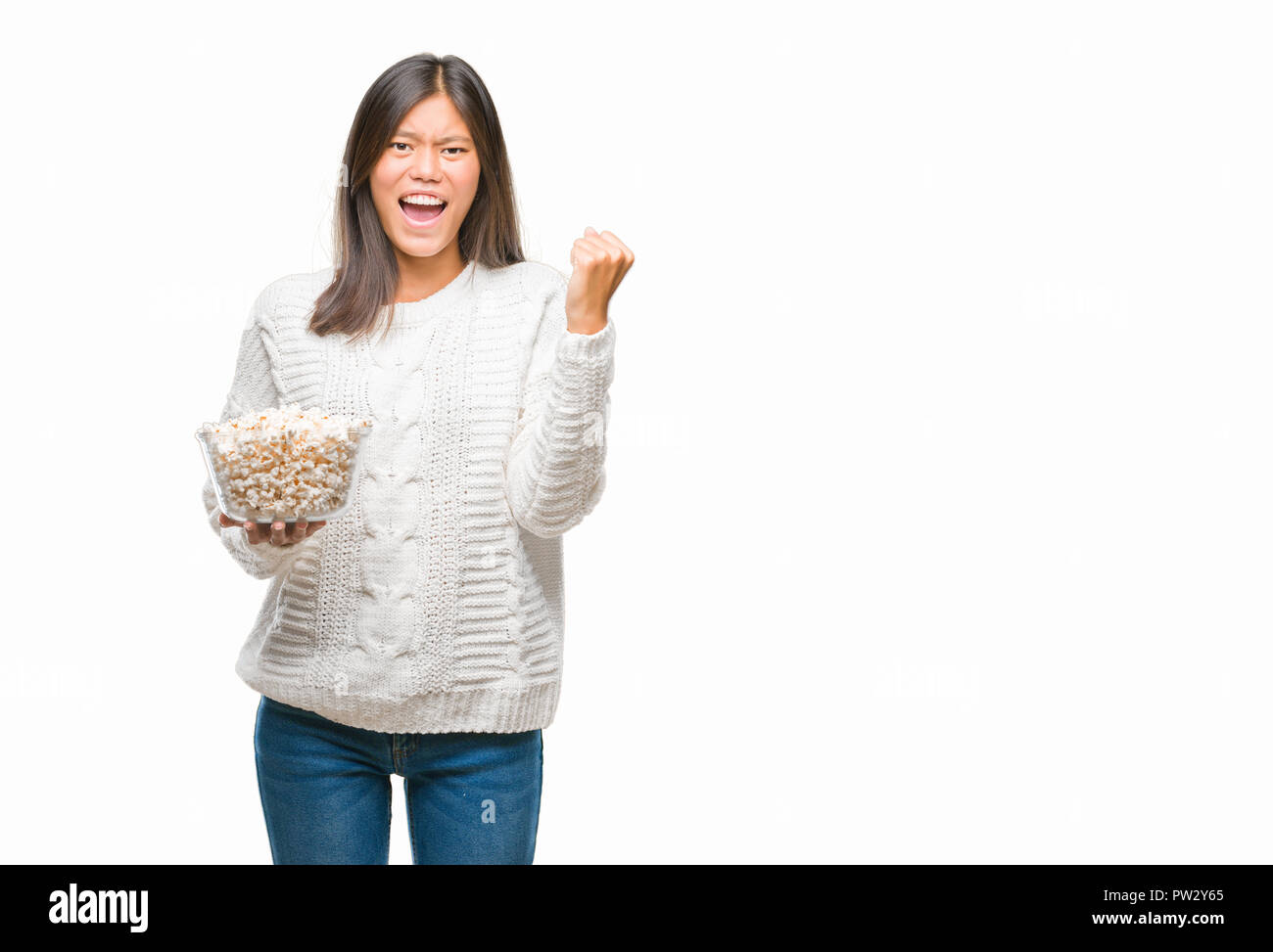 Young asian woman eating popcorn over isolated background screaming ...