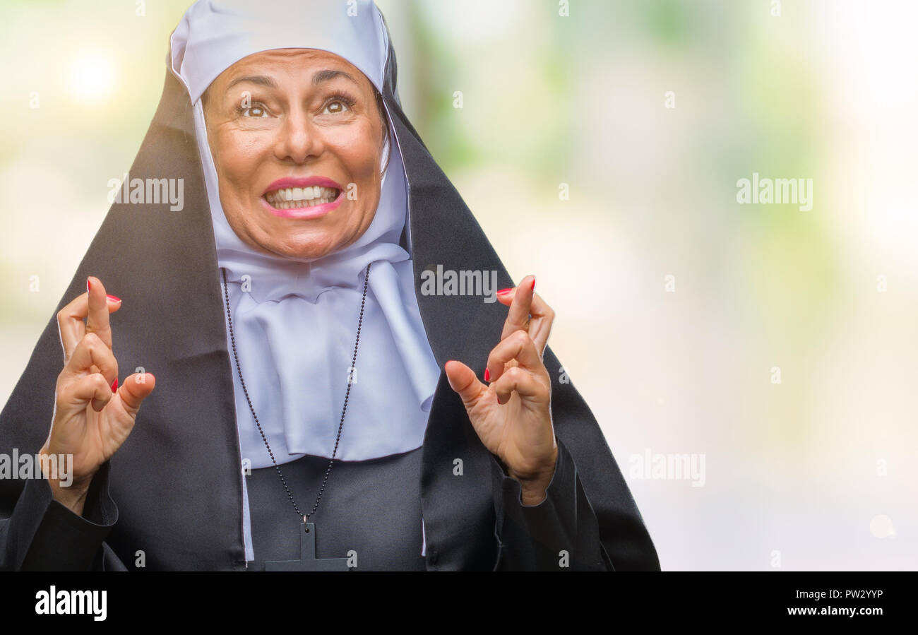 Middle age senior christian catholic nun woman over isolated background ...