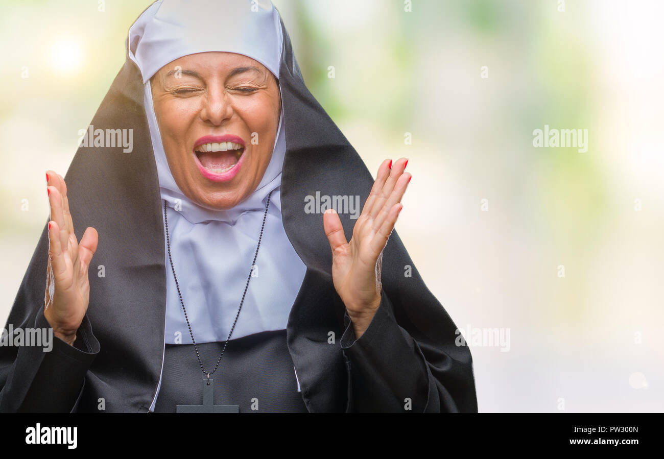 Middle age senior christian catholic nun woman over isolated background ...