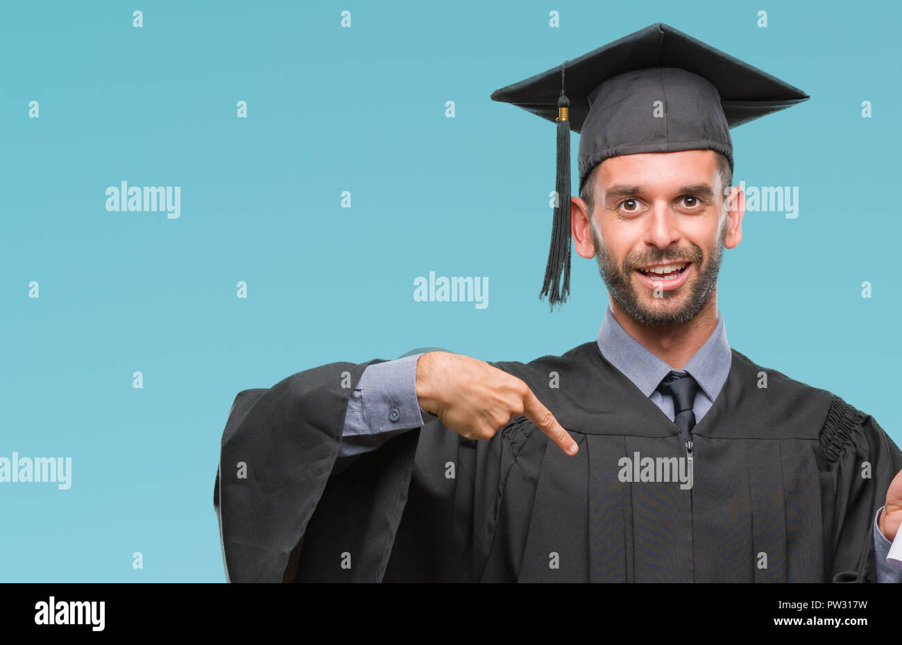 Young handsome graduated man holding degree over isolated background ...
