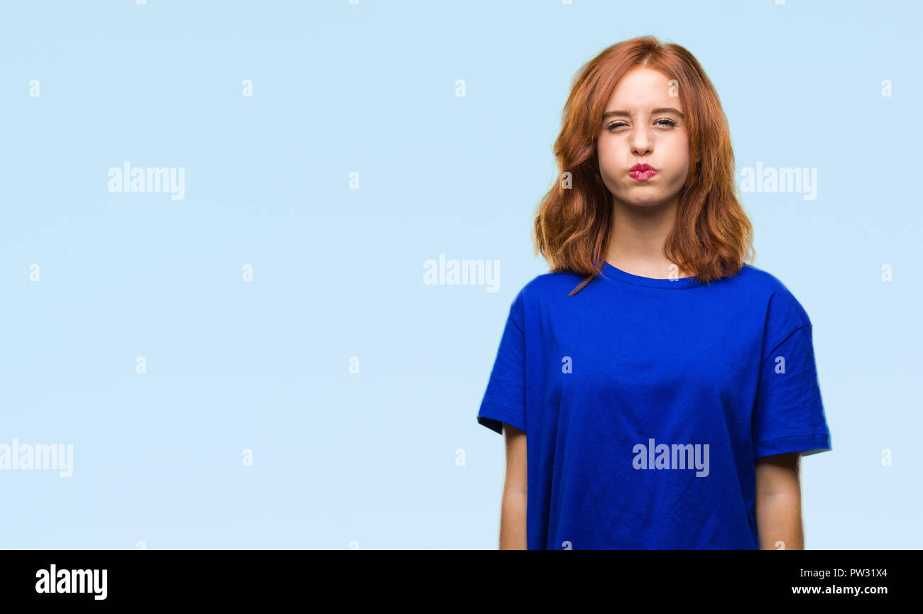 Young beautiful woman over isolated background puffing cheeks with ...