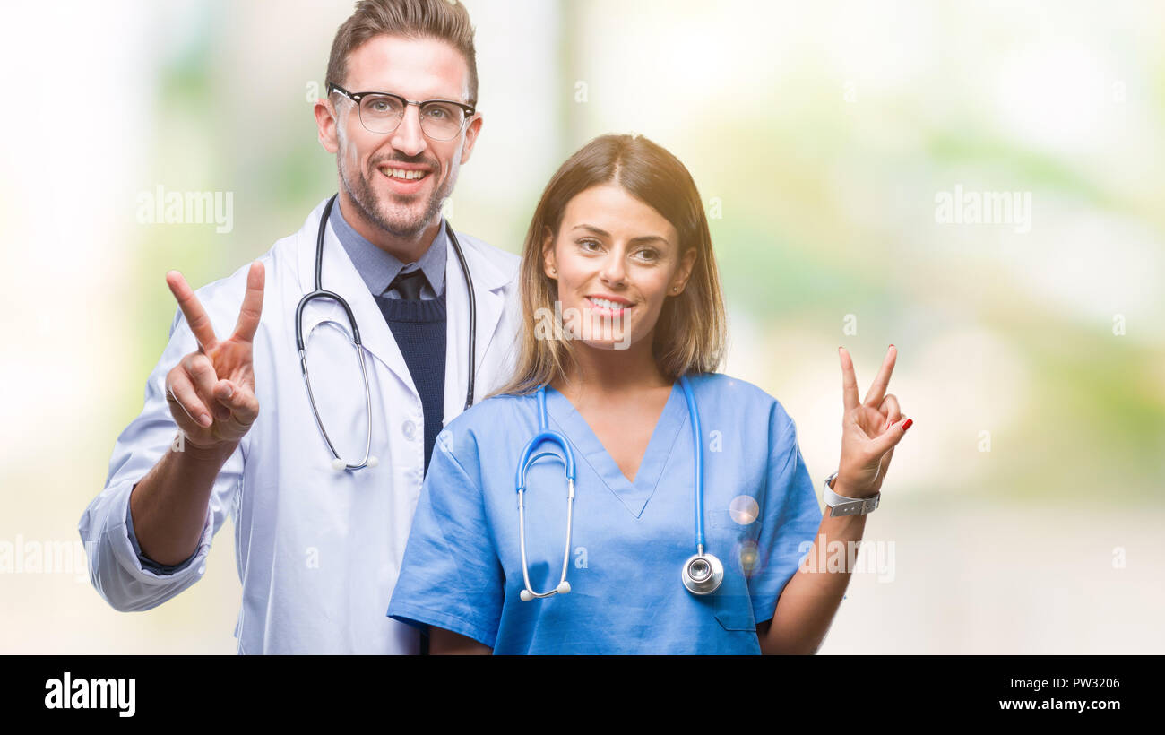 Young couple of doctor and surgeon over isolated background smiling ...