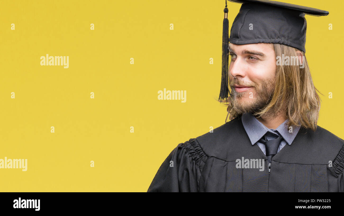 Young handsome graduated man with long hair over isolated background ...