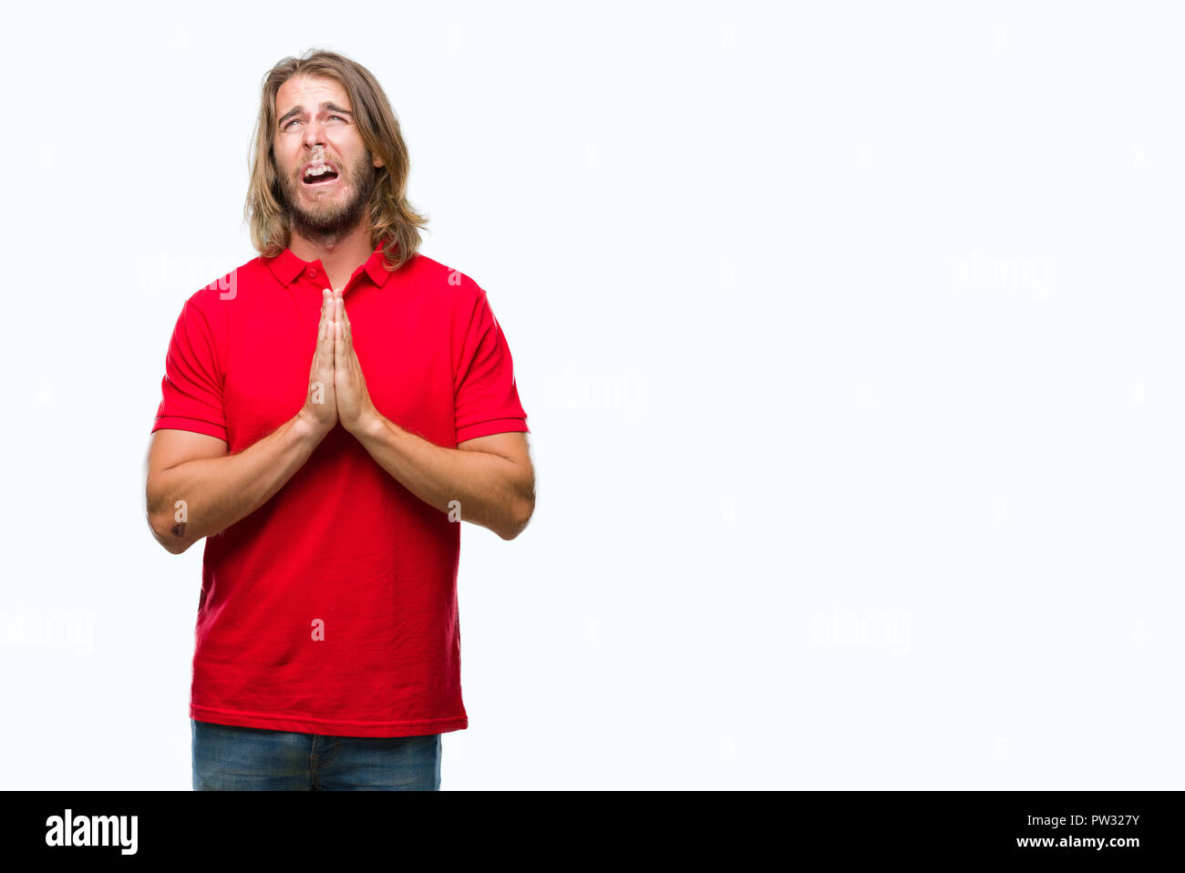 Young handsome man with long hair over isolated background begging and ...
