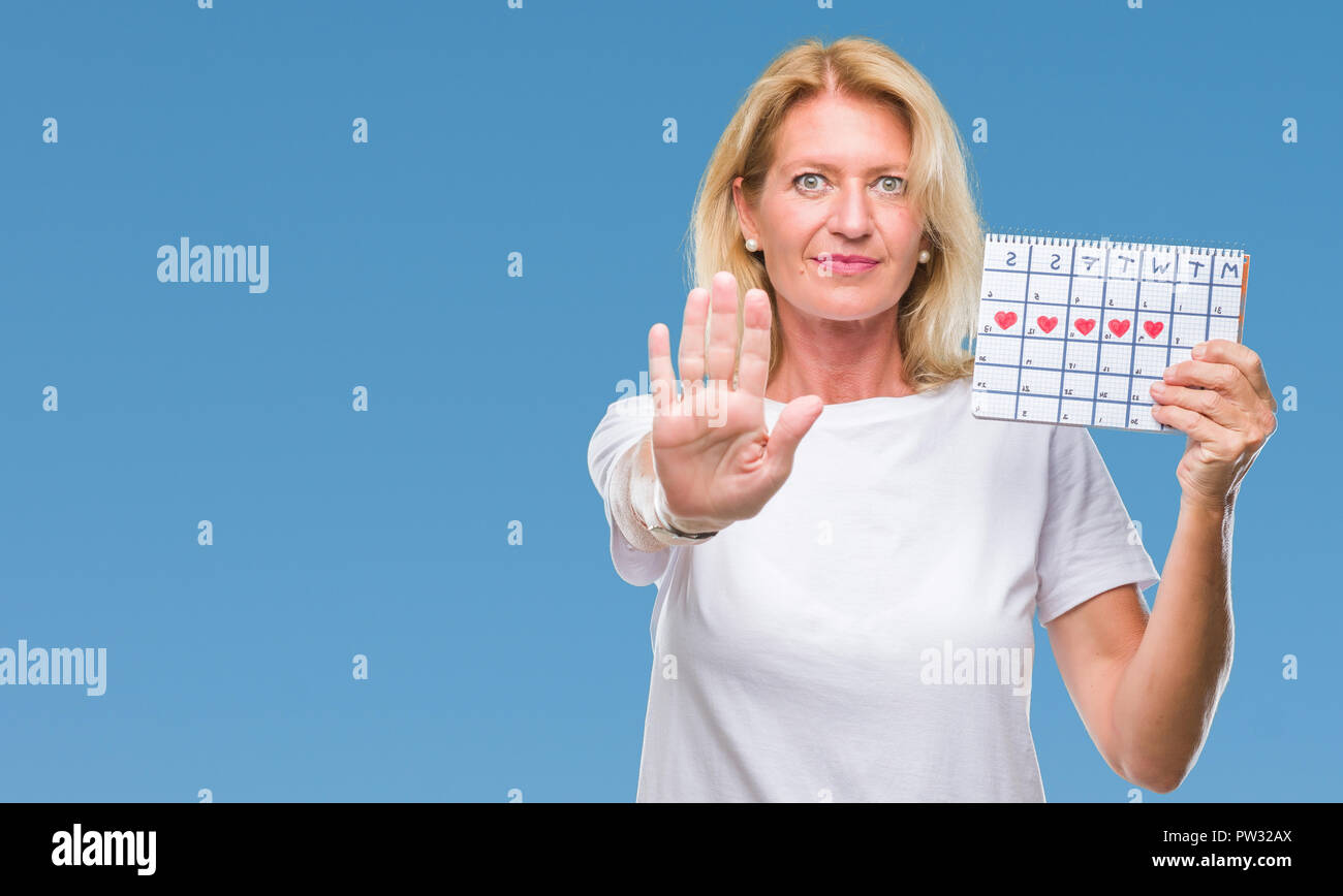 Middle age blonde woman holding menstruation calendar ver isolated ...