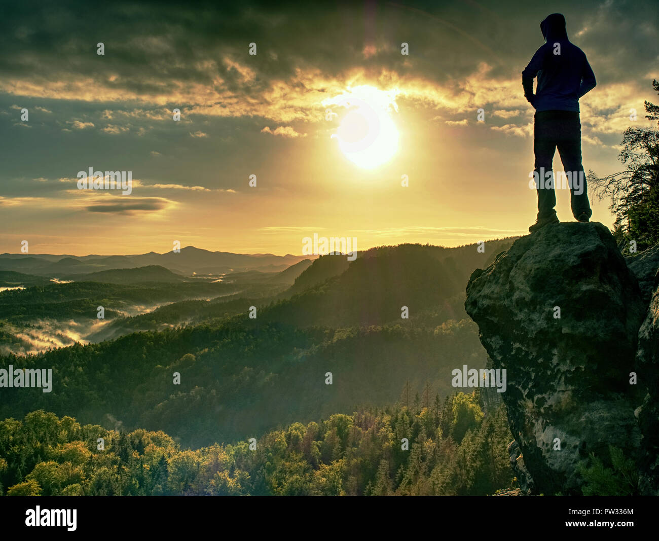 Man walking on the edge of a cliff at summit. Hrensko range, Czech ...