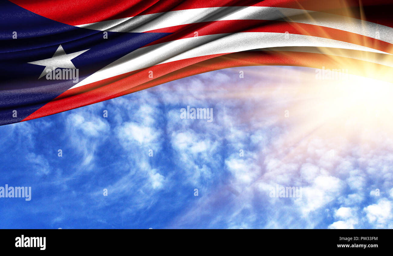 the flag of Puerto Rico in the rays of the summer sun, in the sky ...
