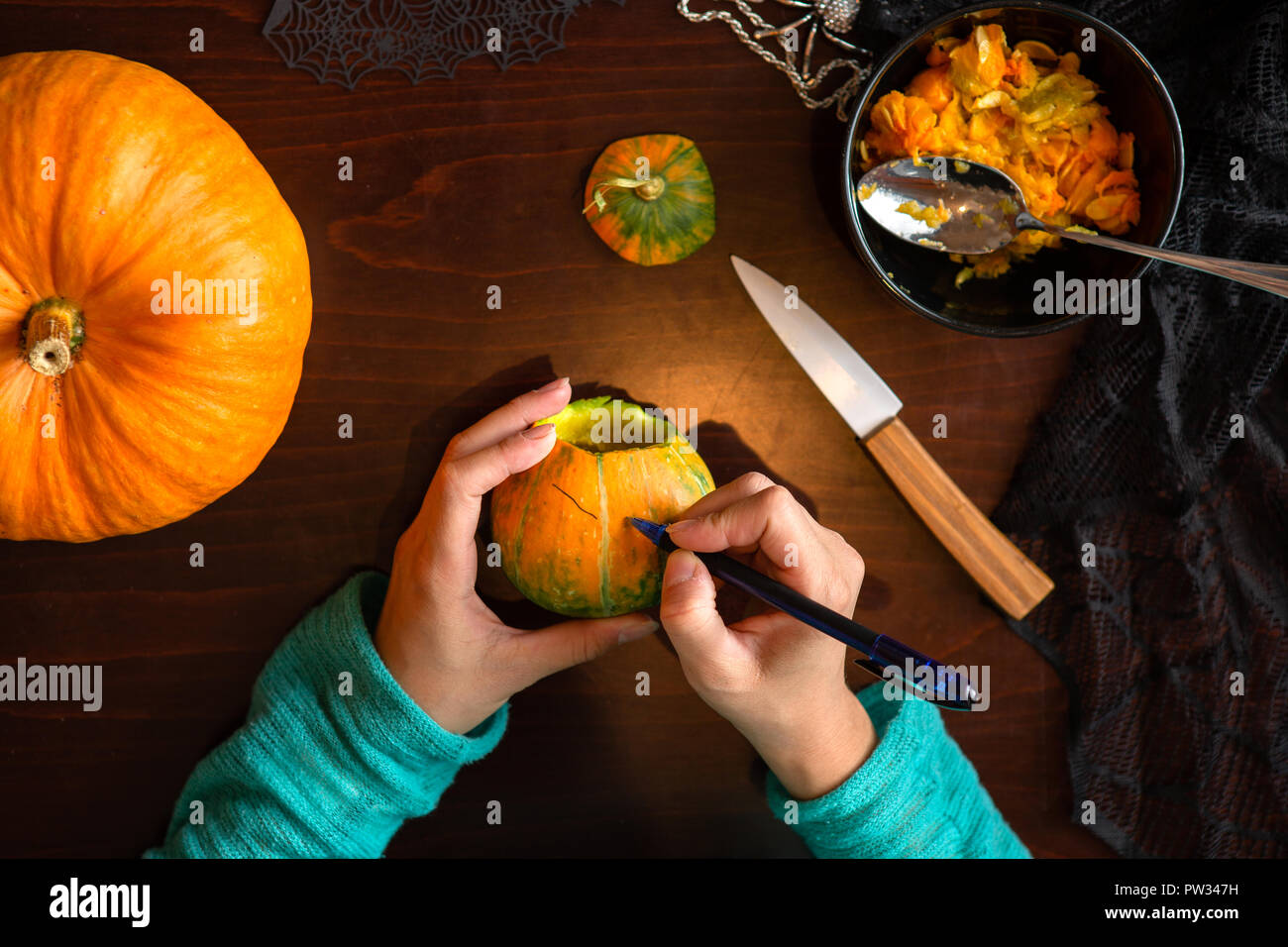 Photo of hands of man drawing on pumpkin face Stock Photo - Alamy