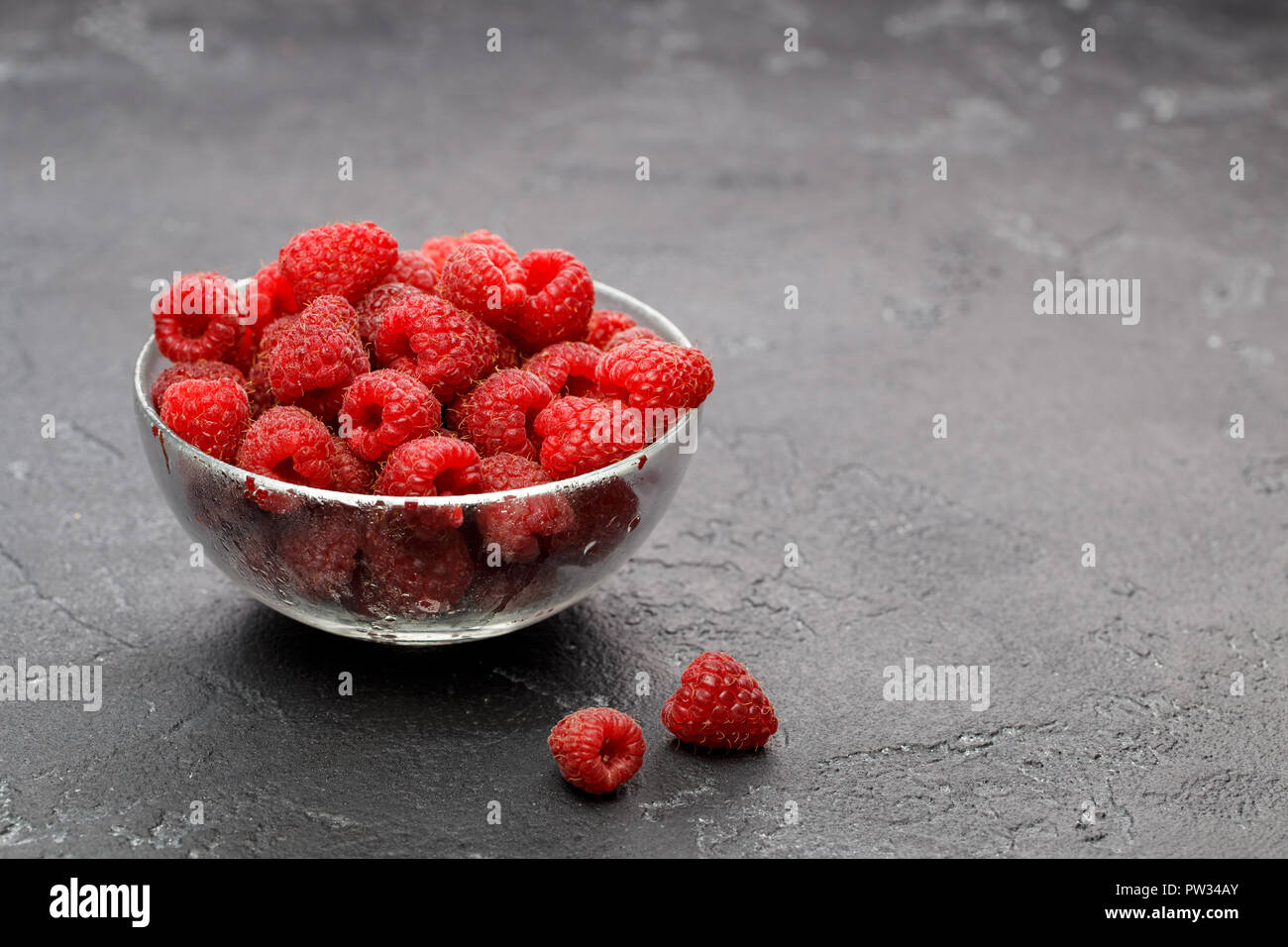 Photo of raspberries in transparent glass cup Stock Photo - Alamy