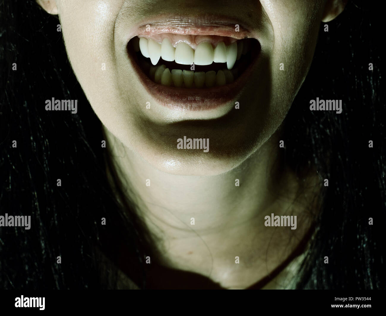 Halloween horror. Crazy bloody scary vampire girl with fangs screaming ...