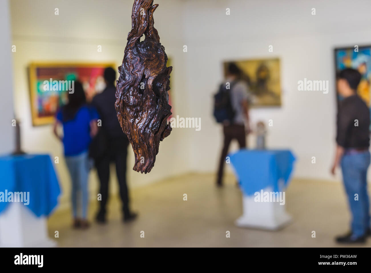 Unknown people looking at paintings and talking about them in an art ...