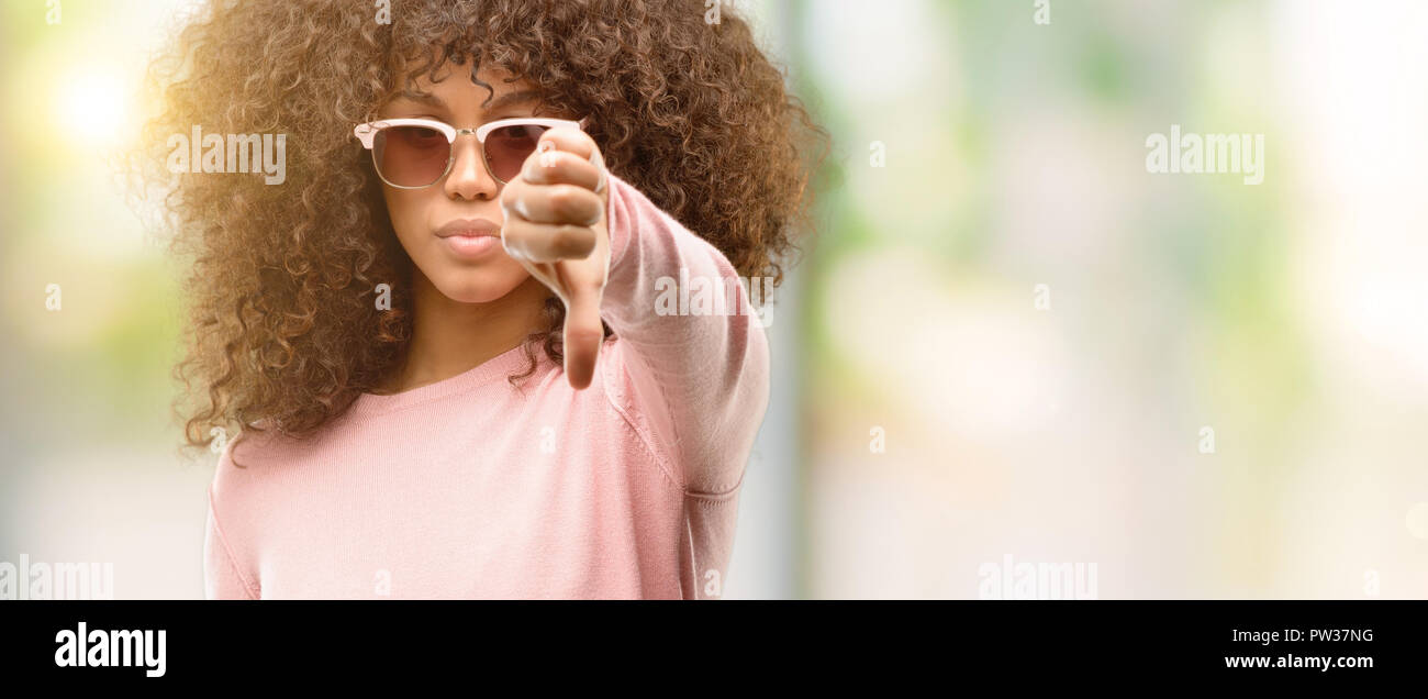 African american woman wearing pink sunglasses looking unhappy and ...