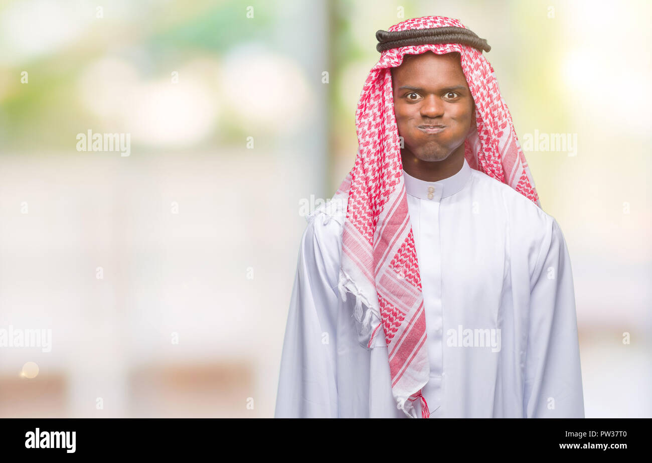 Young arabic african man wearing traditional keffiyeh over isolated ...