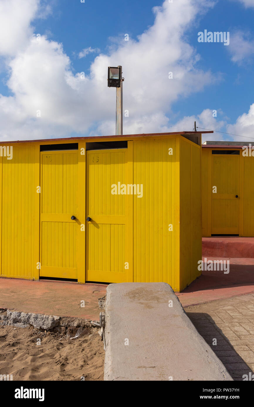 Beautiful yellow Bathing houses on the sandy beach. Empty shelters on a ...