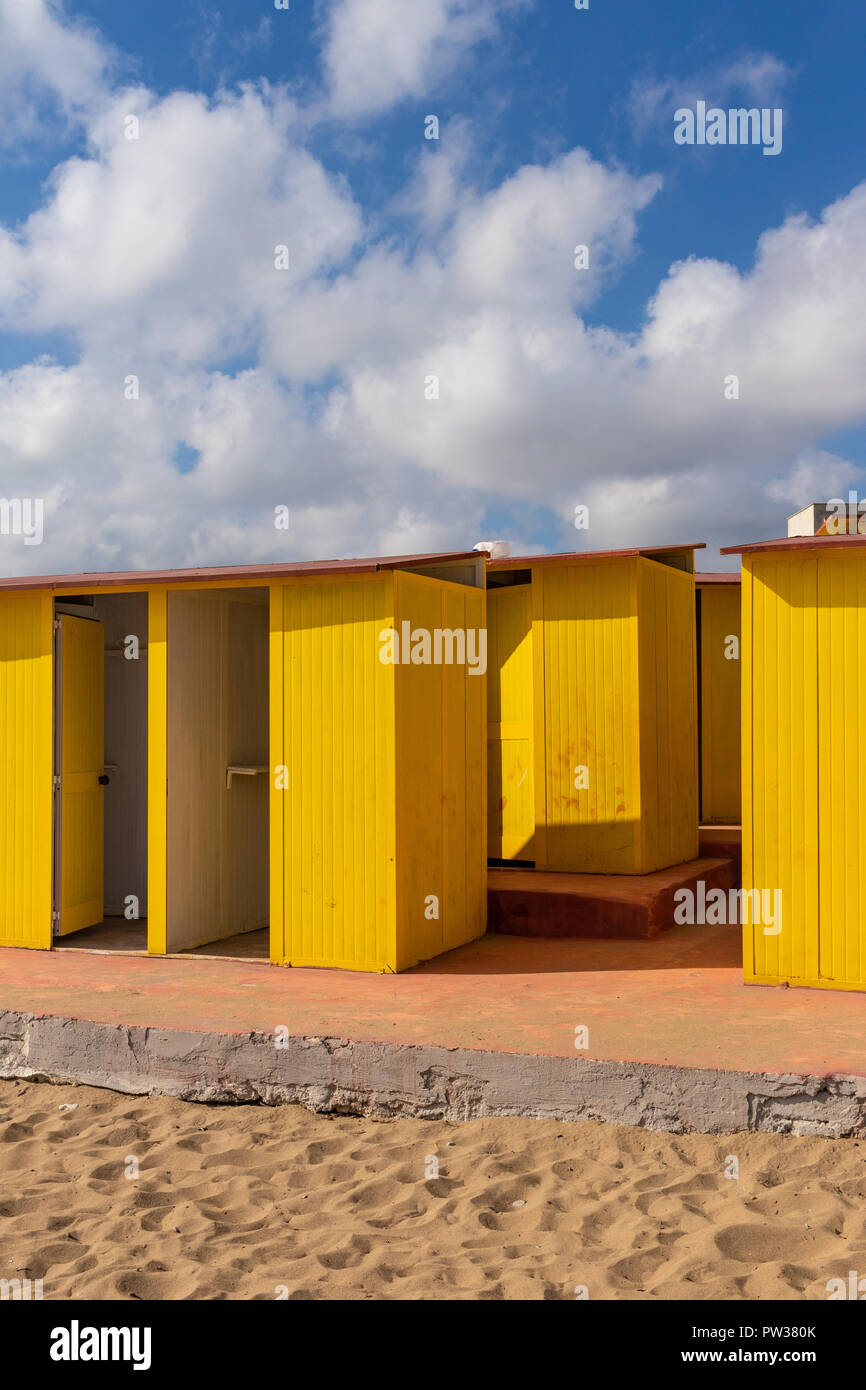 Beautiful yellow Bathing houses on the sandy beach. Empty shelters on a ...