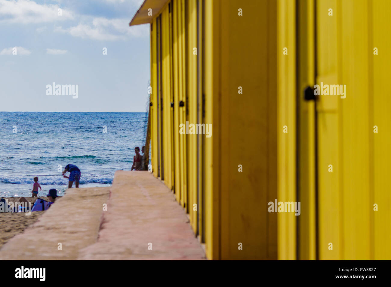 Beautiful yellow Bathing houses on the sandy beach. Empty shelters on a ...