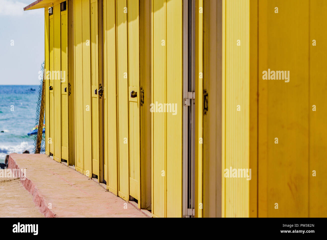 Beautiful yellow Bathing houses on the sandy beach. Empty shelters on a ...