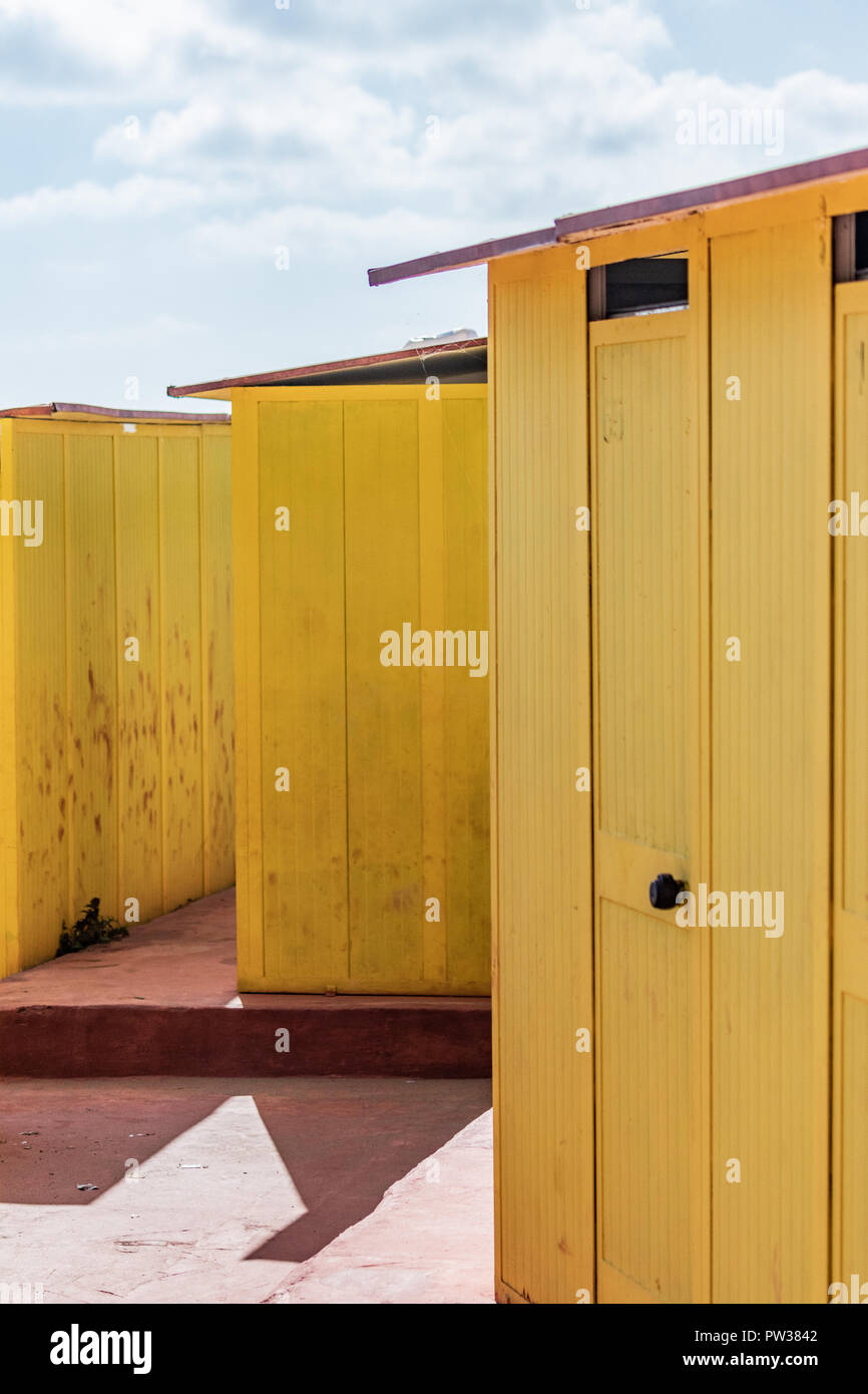 Beautiful yellow Bathing houses on the sandy beach. Empty shelters on a ...