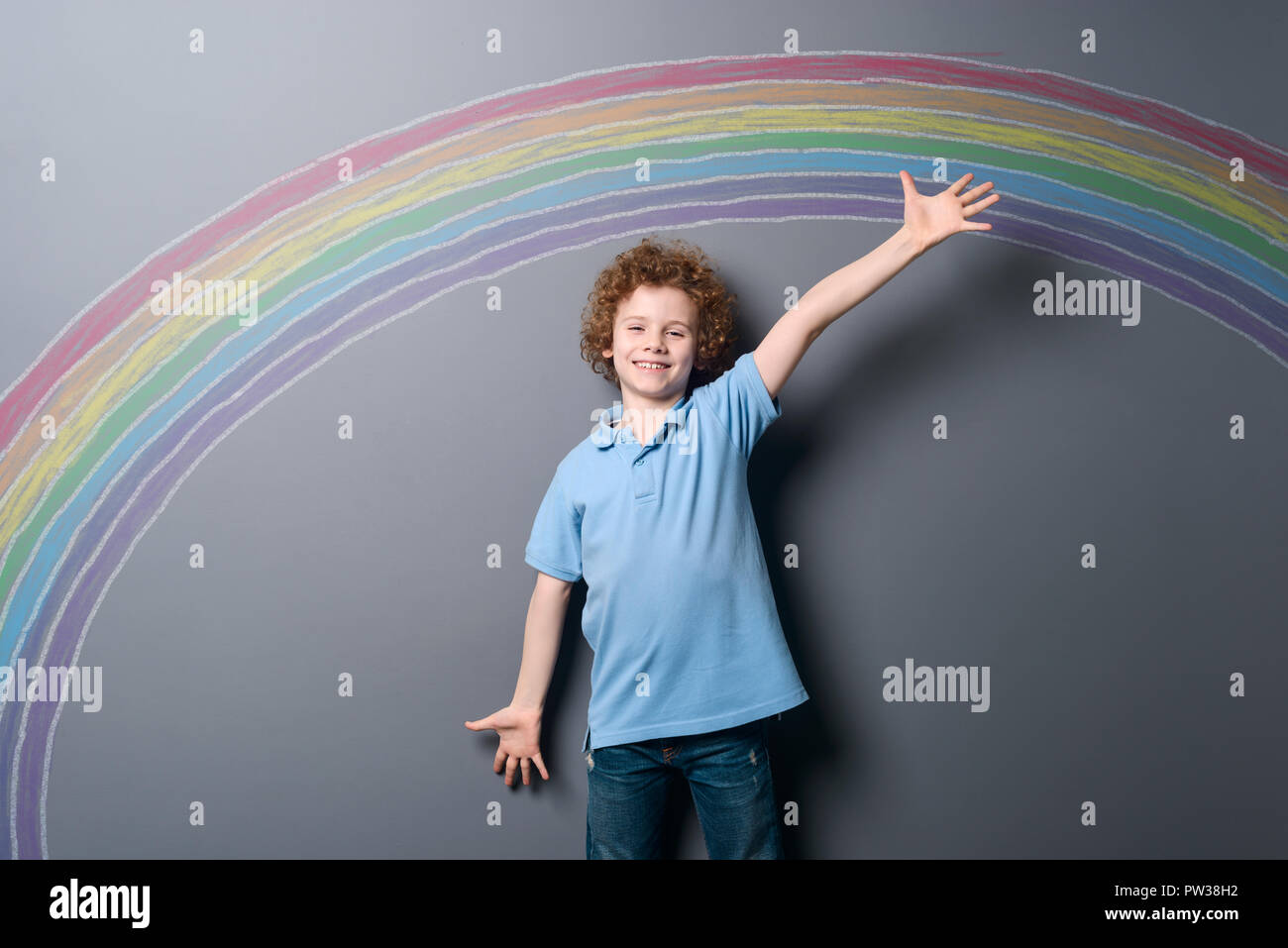 Happy boy and colorful rainbow Stock Photo - Alamy