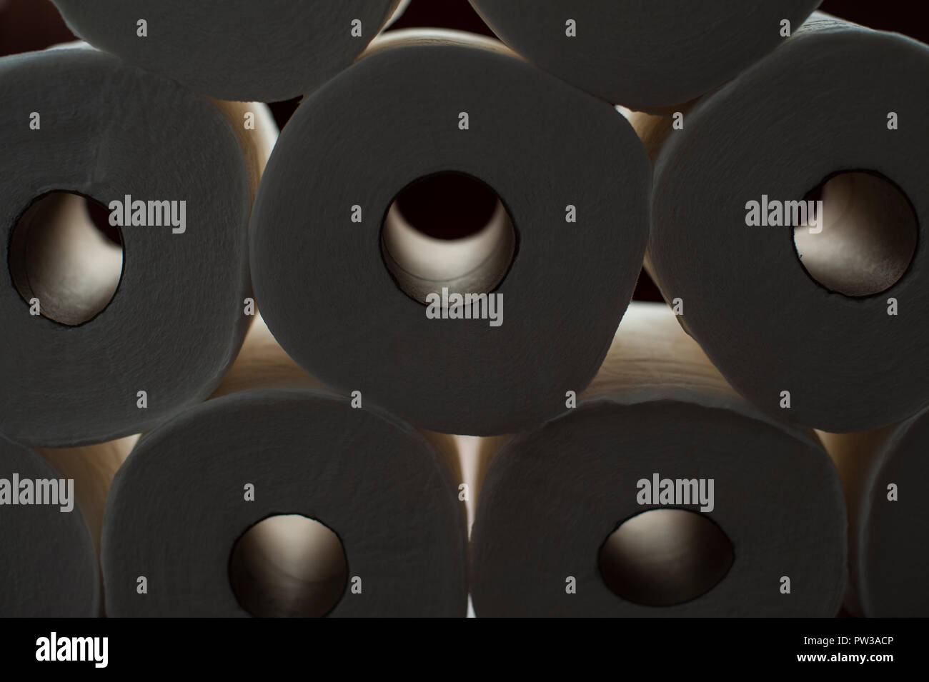 Toilet paper stacked with heavy contrast creating abstract patterns ...