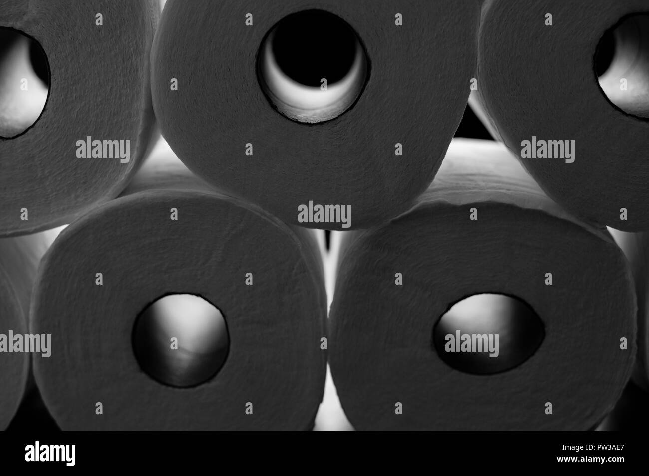 Toilet paper stacked with heavy contrast creating abstract patterns ...