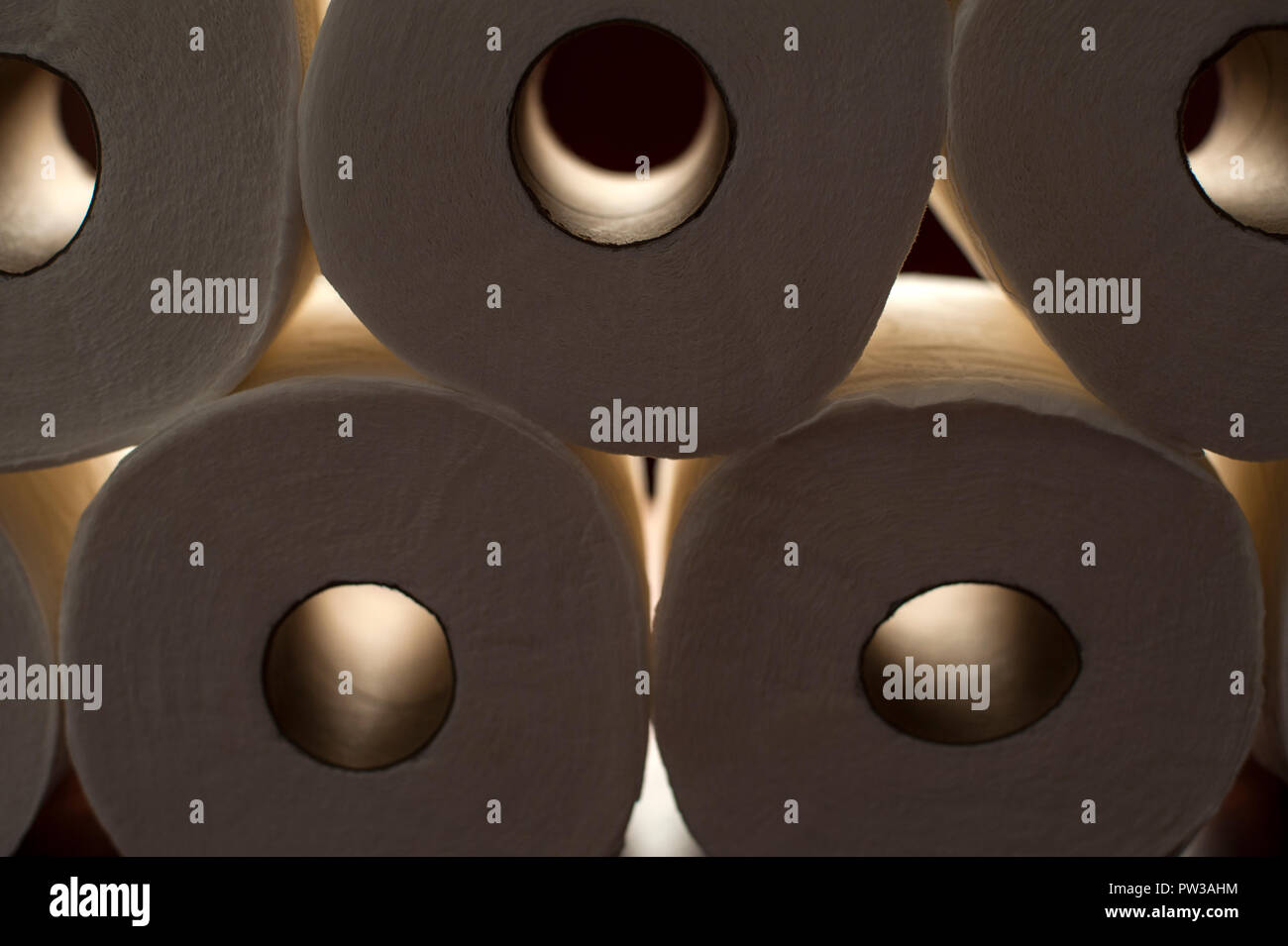 Toilet paper stacked with heavy contrast creating abstract patterns ...