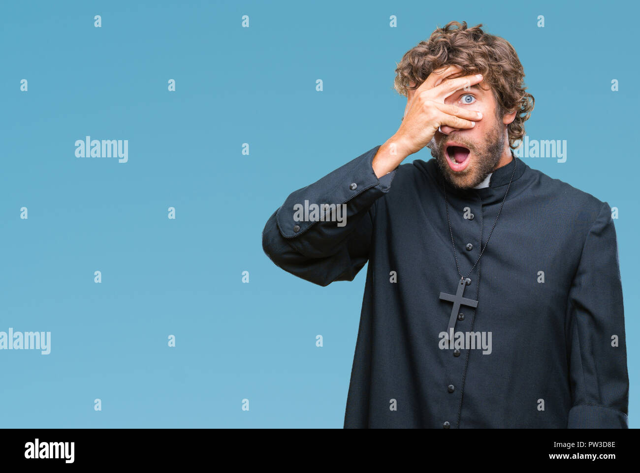 Handsome hispanic catholic priest man over isolated background peeking ...