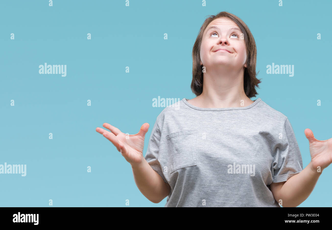 Young adult woman with down syndrome over isolated background crazy and ...
