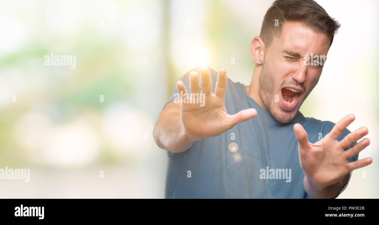 Handsome young casual man afraid and terrified with fear expression ...