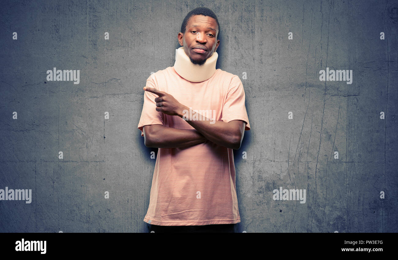 Injured african black man wearing neck brace pointing away side with ...