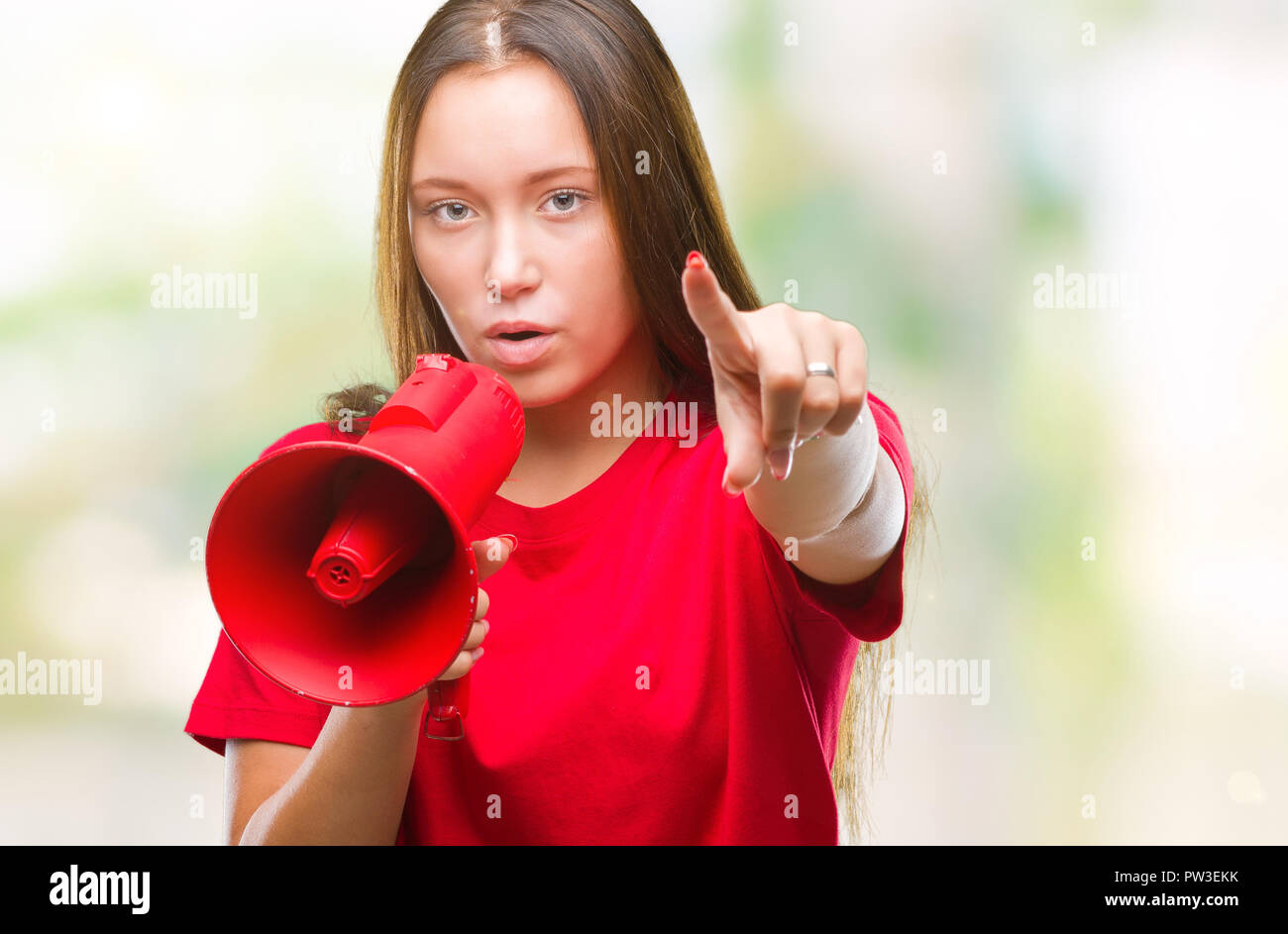 Young caucasian woman yelling through megaphone over isolated ...