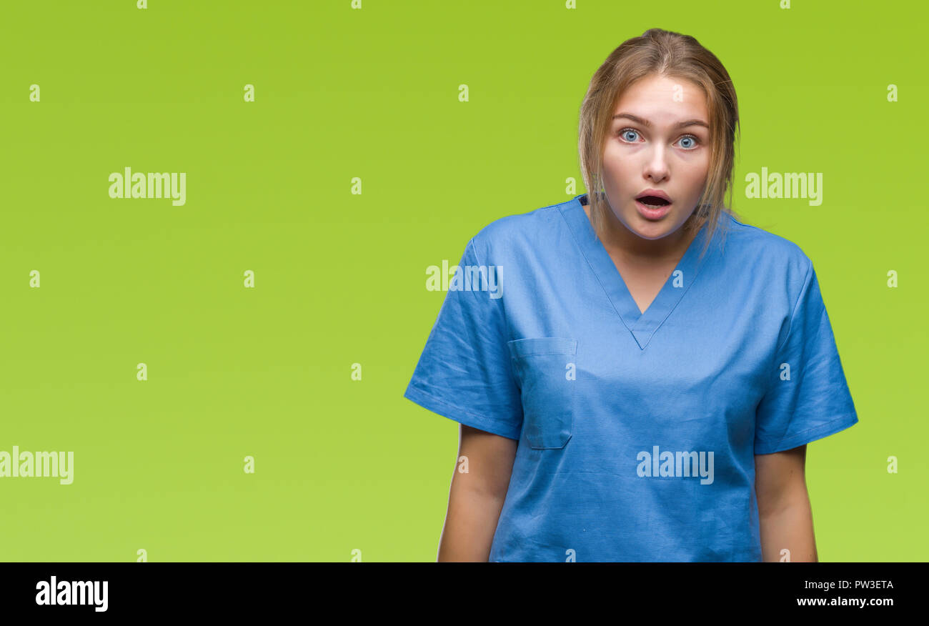 Young caucasian nurse woman wearing surgeon uniform over isolated ...