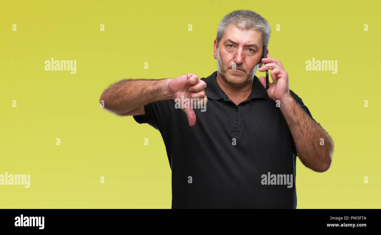 Handsome senior man talking on smartphone over isolated background with ...