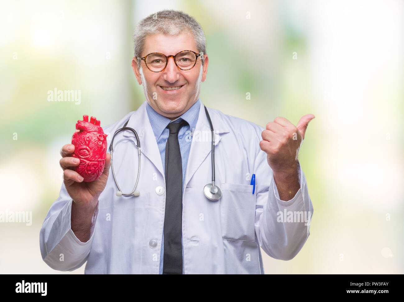 Handsome senior cardiologist doctor man holding heart over isolated ...