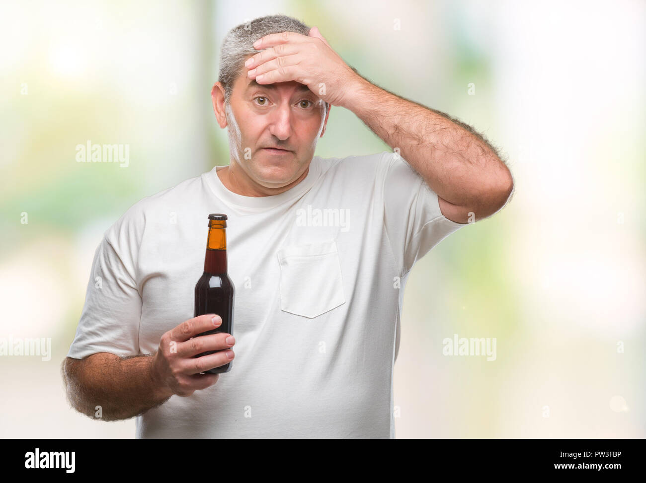 Handsome senior man drinking beer bottle over isolated background ...