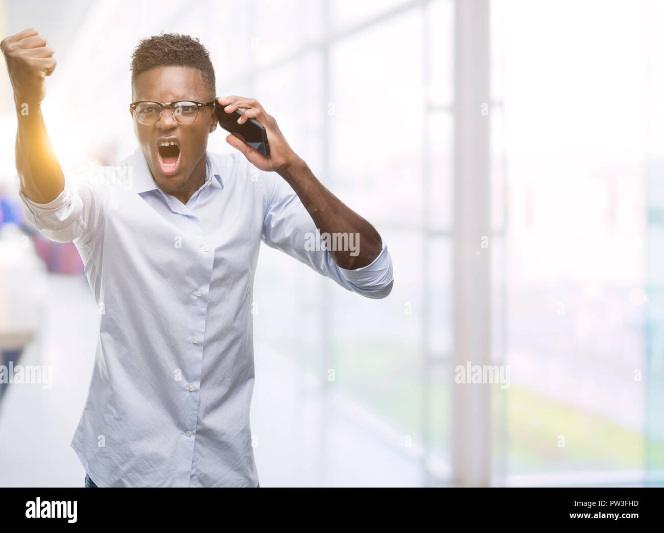 Young african american man using smartphone annoyed and frustrated ...