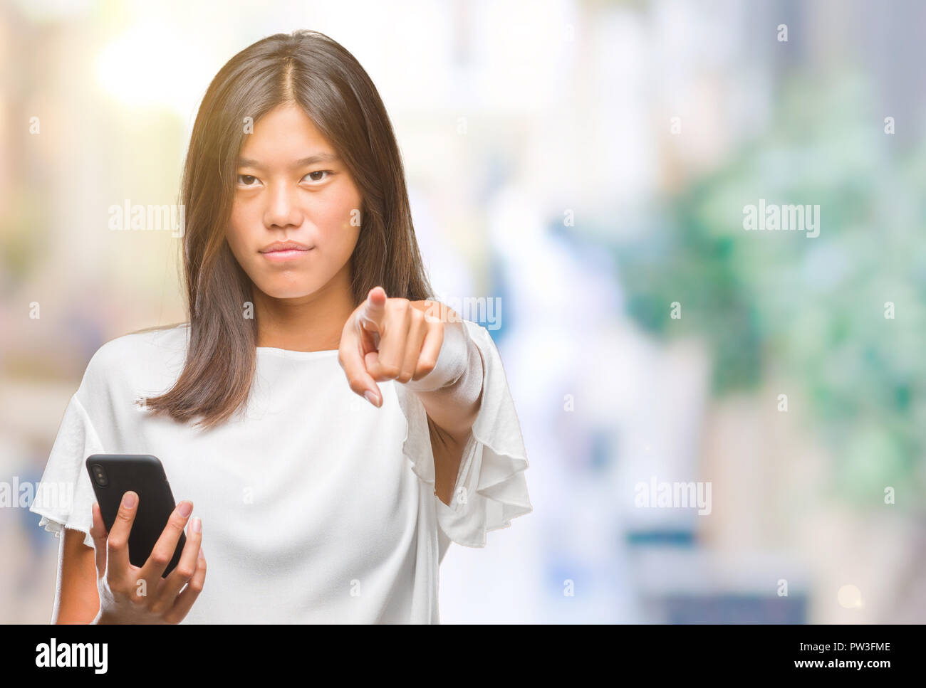 Young asian woman texting using smartphone over isolated background ...