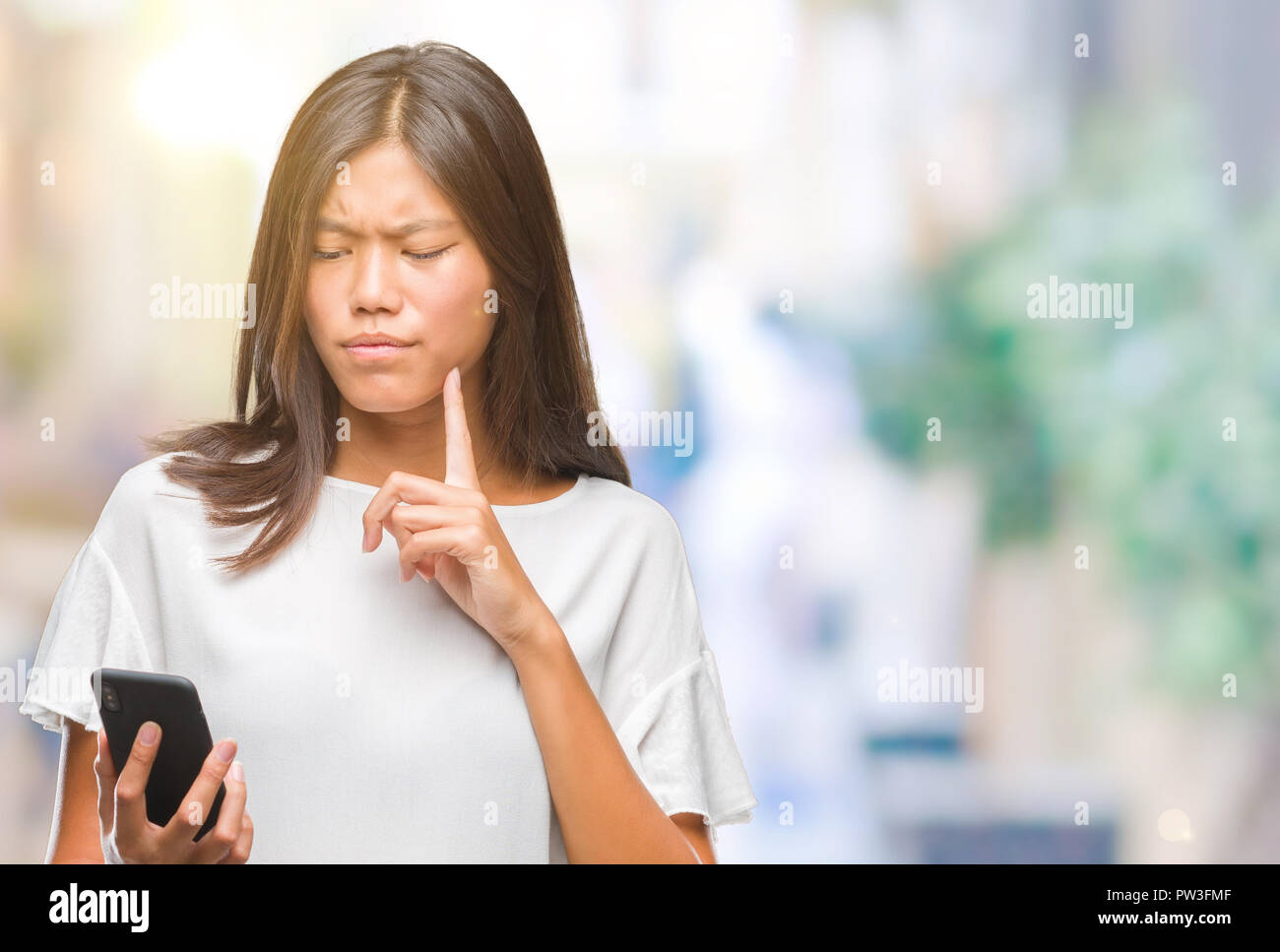 Young asian woman texting using smartphone over isolated background ...